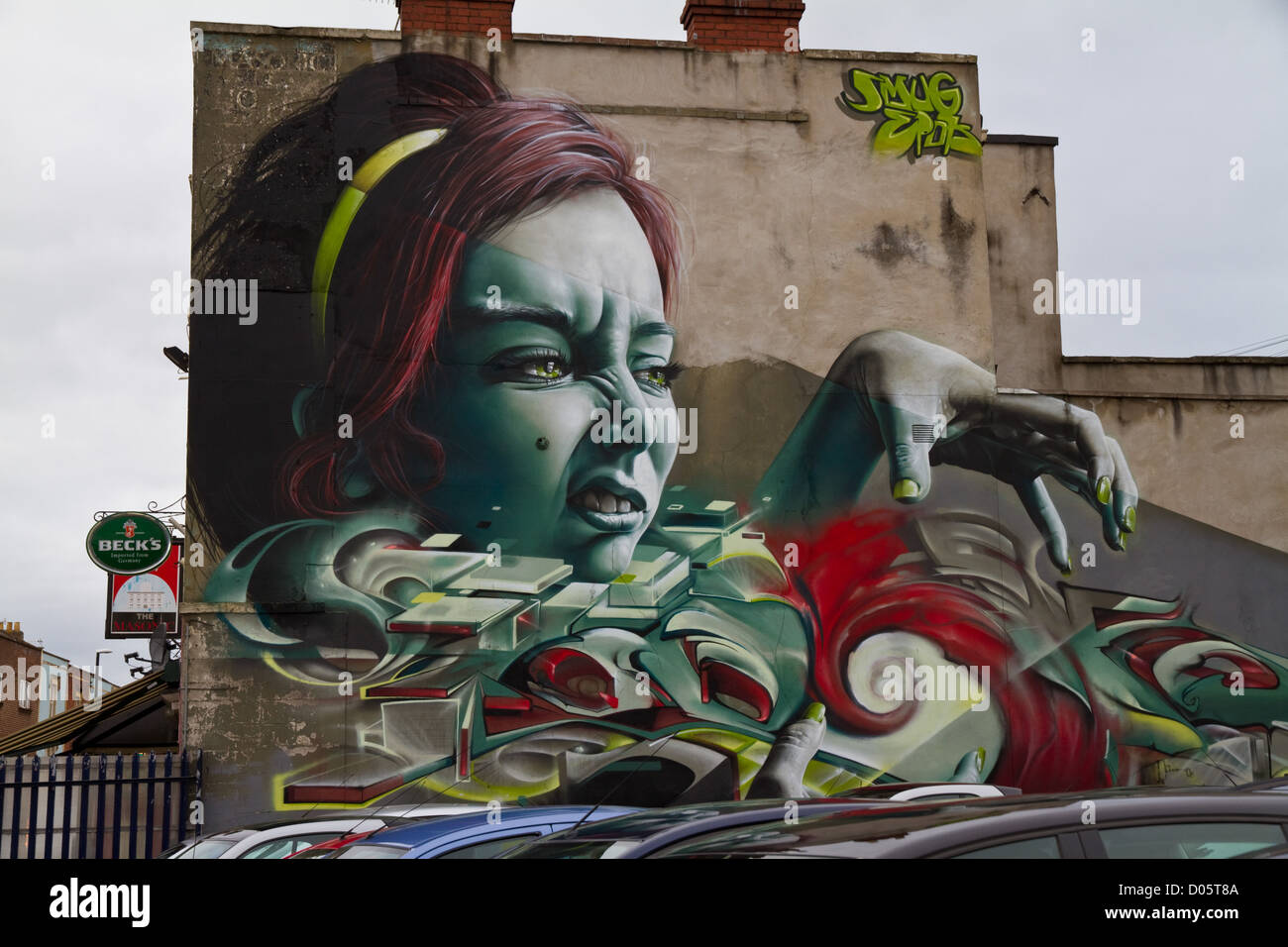 Graffiti of a sneering woman's face with grabbing hand, green eyes and ...