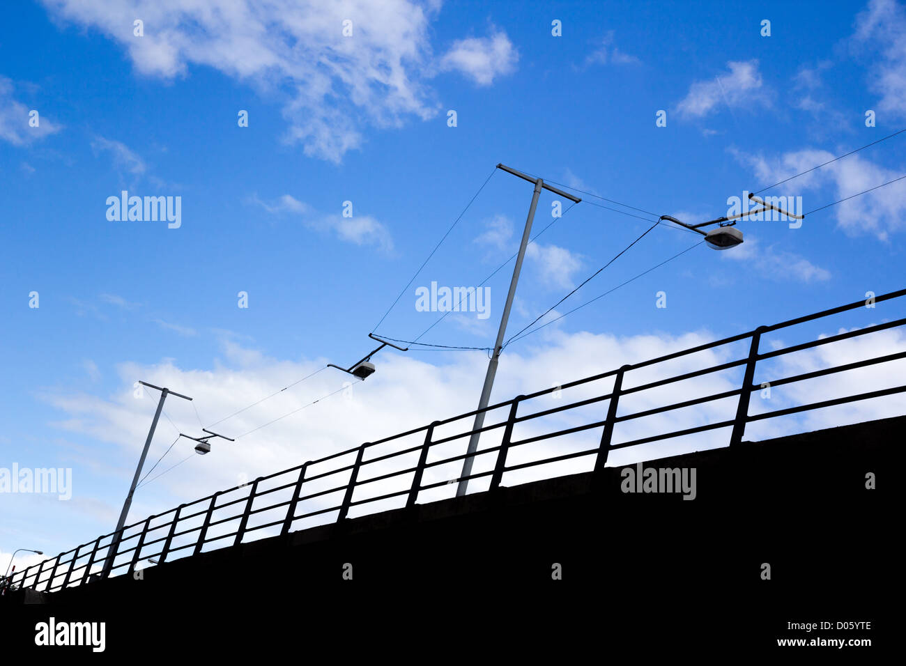 Raised road with railing and street lights strung across the road Stock ...