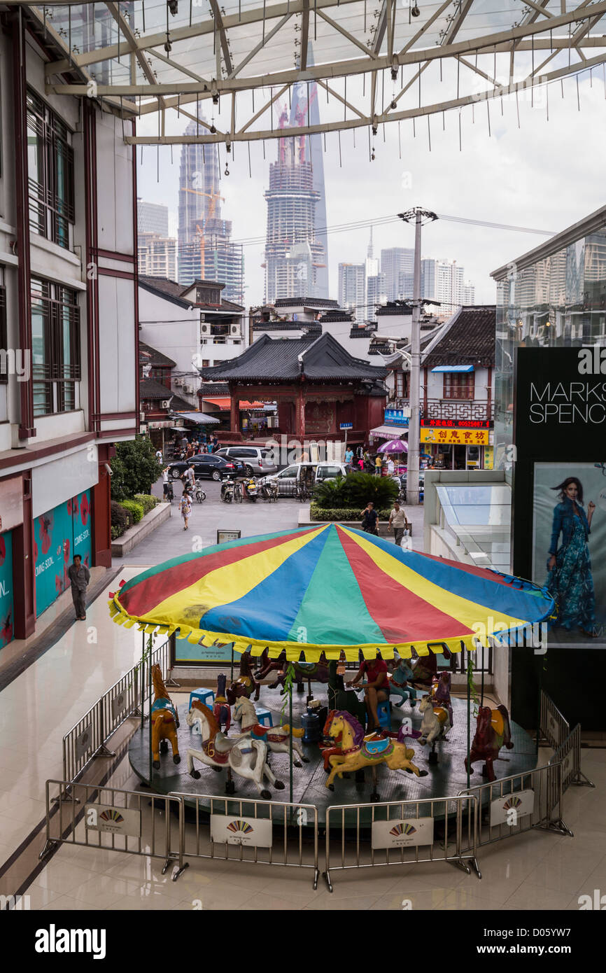 A children's carousel against the modern skyline of Shanghai, China ...