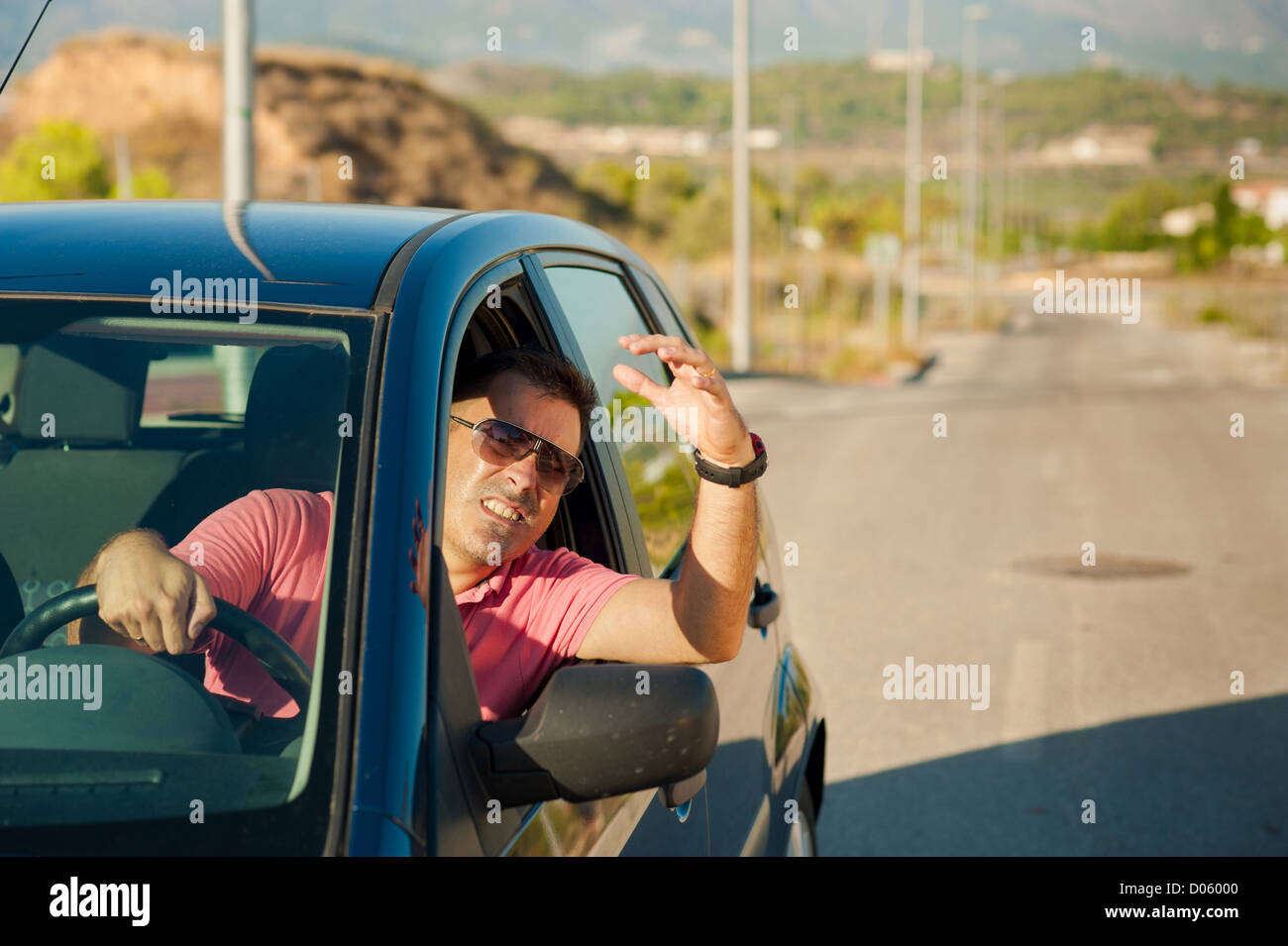 Guy gesturing out of the window of his car Stock Photo - Alamy