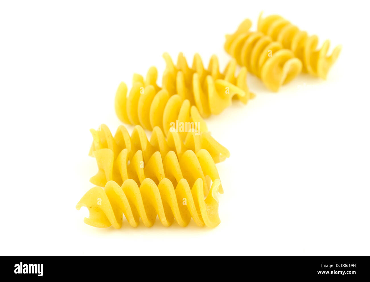 Golden dry rotini pasta isolated on white background Stock Photo - Alamy