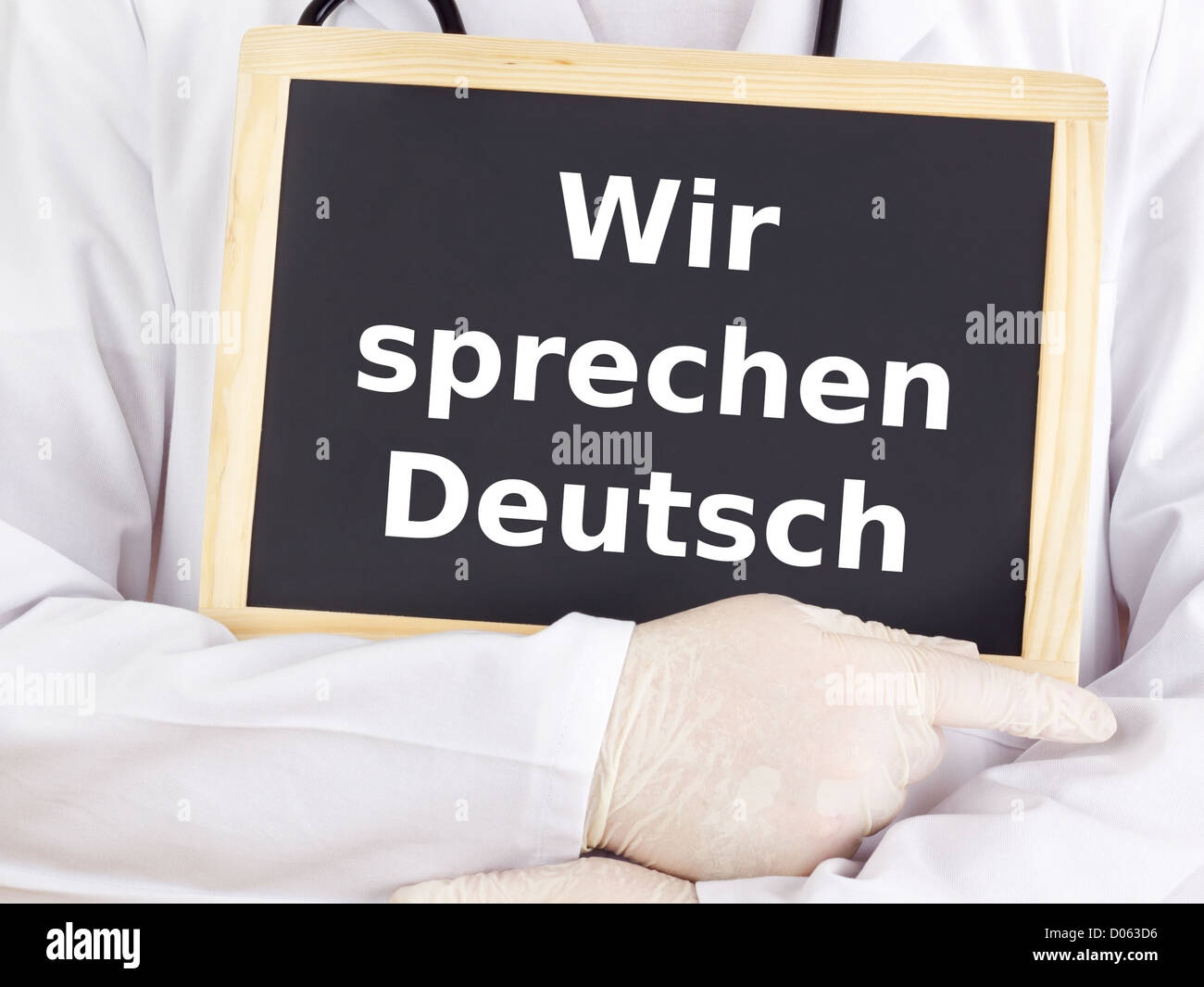 Doctor shows information: we speak german Stock Photo - Alamy