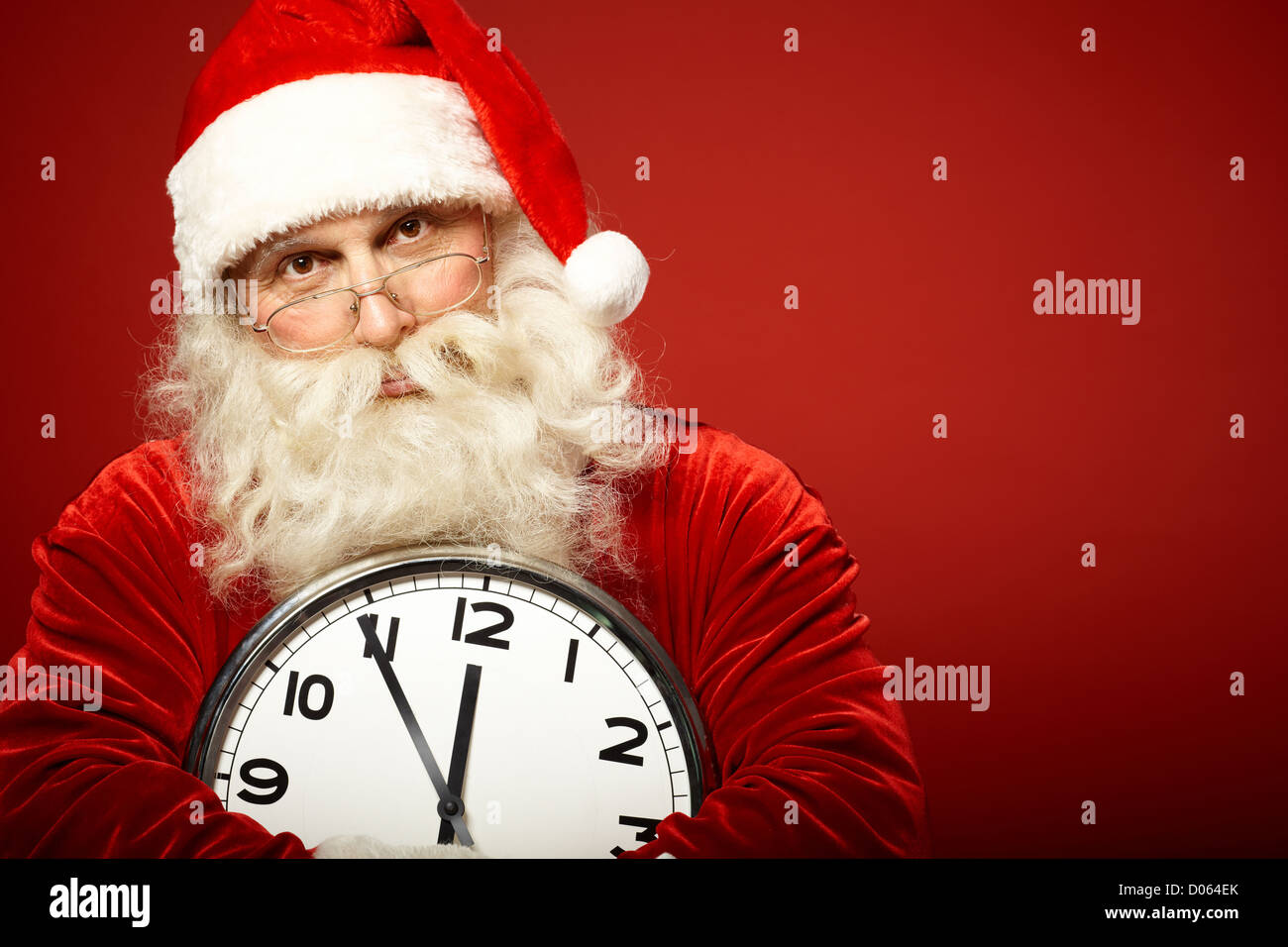 Photo of Santa holding clock showing five minutes to midnight Stock ...