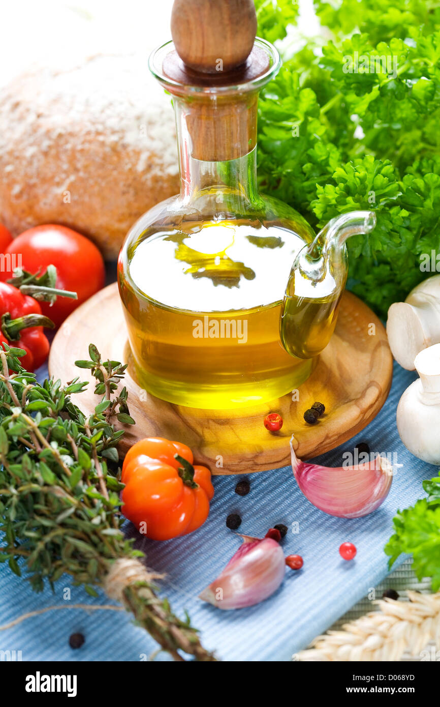 Bottle of Olive oil and condiments on blue napkin Stock Photo - Alamy