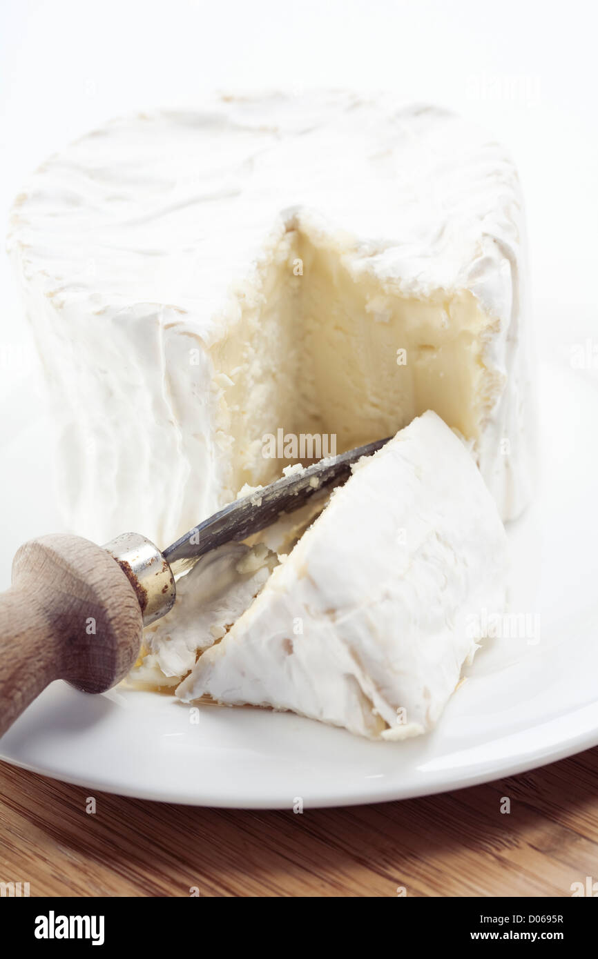 Wheel of French soft cheese on a plate and a traditional rural knife ...
