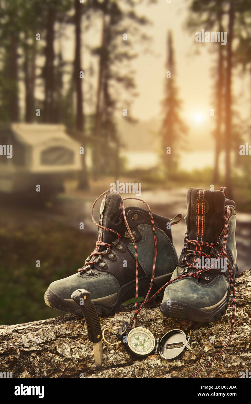 Hiking boots with compass on tree trunk at campsite Stock Photo - Alamy