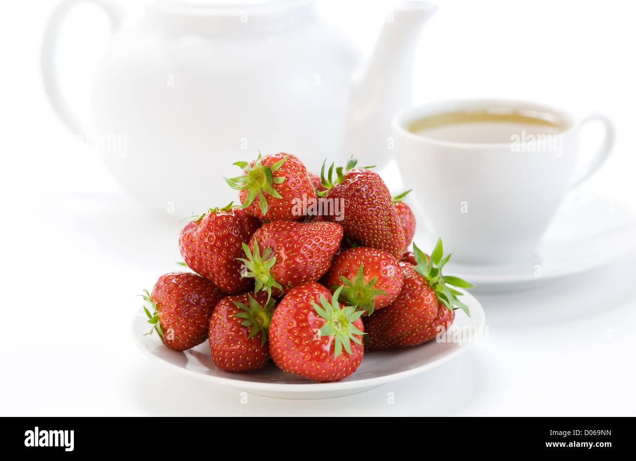 strawberry and white teacup with hot tea on white background Stock ...