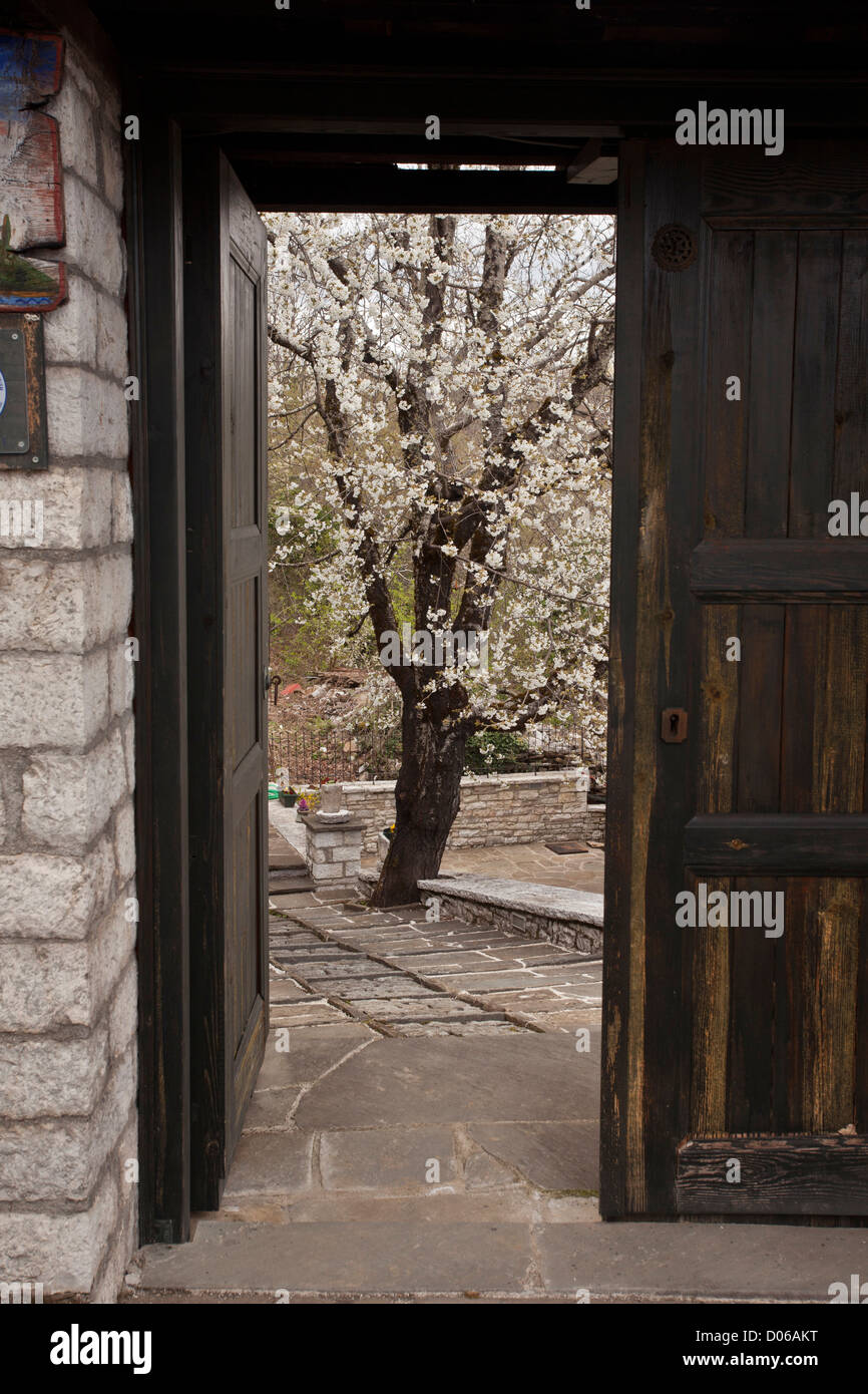 Glimpse through old gateway into courtyard with cherry tree; Dhilopho ...