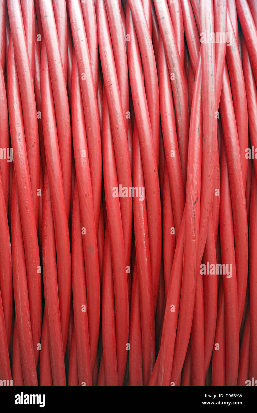 Red textures rolled electricity cables around a large spool Stock Photo ...