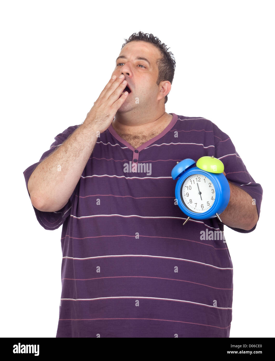 Fat man with a blue alarm yawning clock isolated on white background ...
