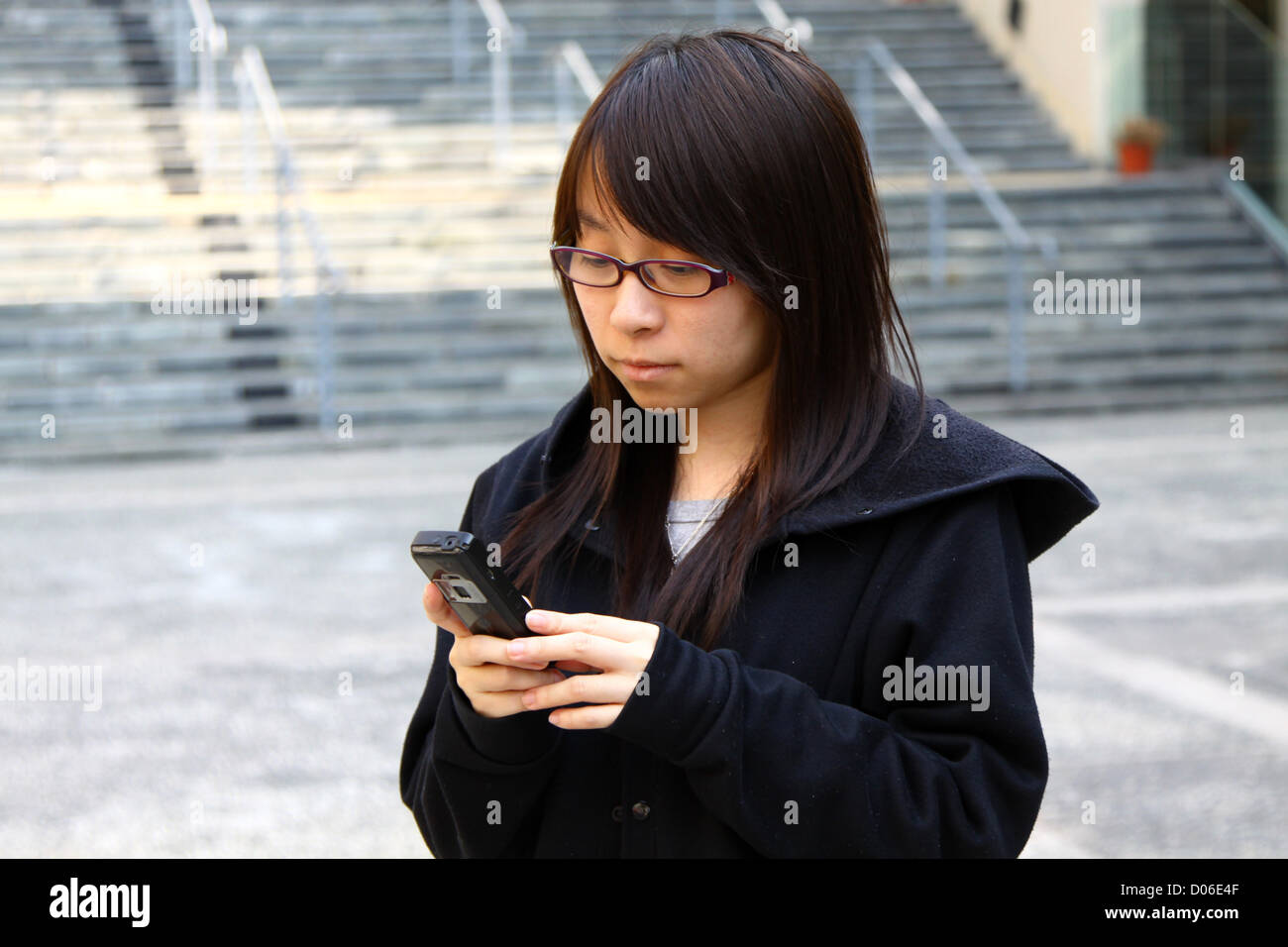 Asian woman texting message by phone Stock Photo - Alamy