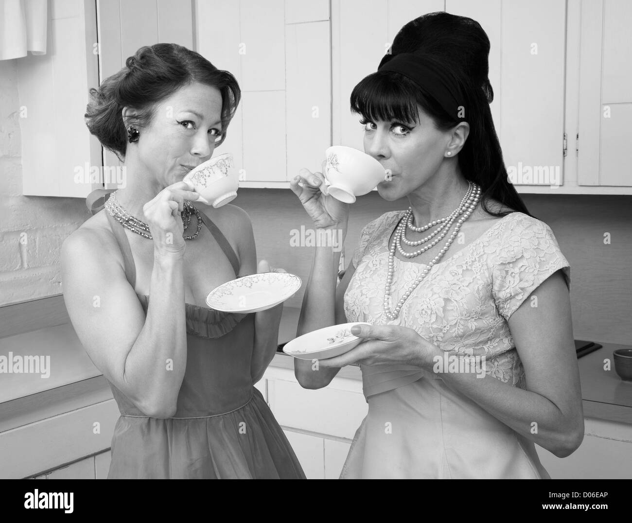 Two retro-styled women drinking coffee in kitchen Stock Photo - Alamy