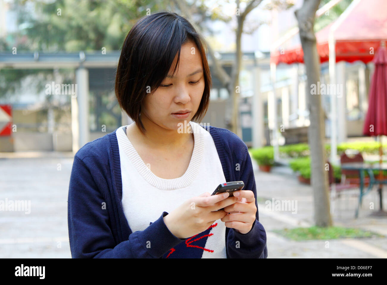 Asian woman texting message by phone Stock Photo - Alamy