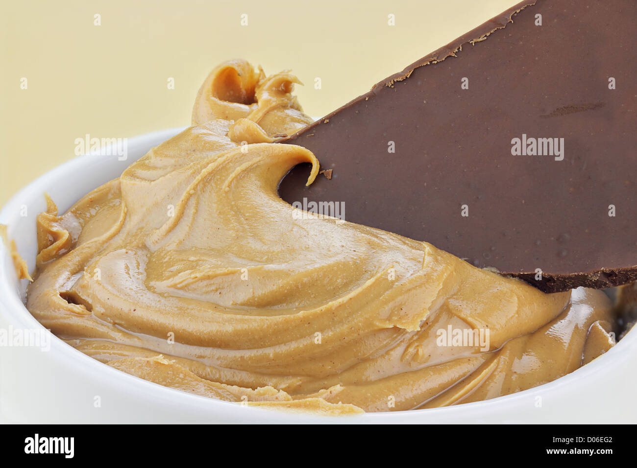 Peanut butter with a piece of a chocolate candy bar dipped into it ...