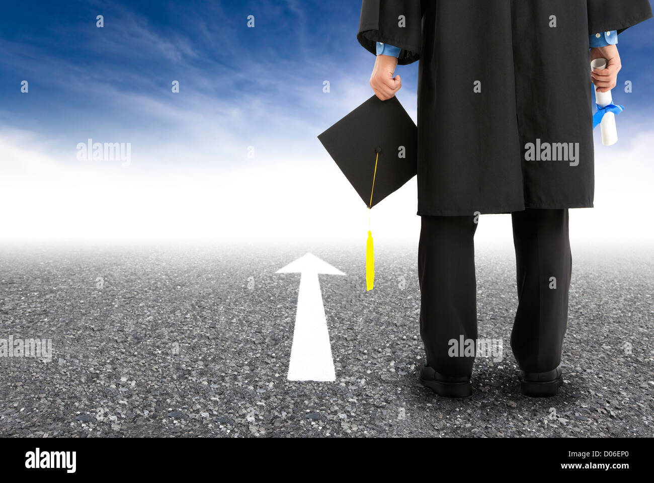 graduate standing on the road and forward arrow Stock Photo - Alamy