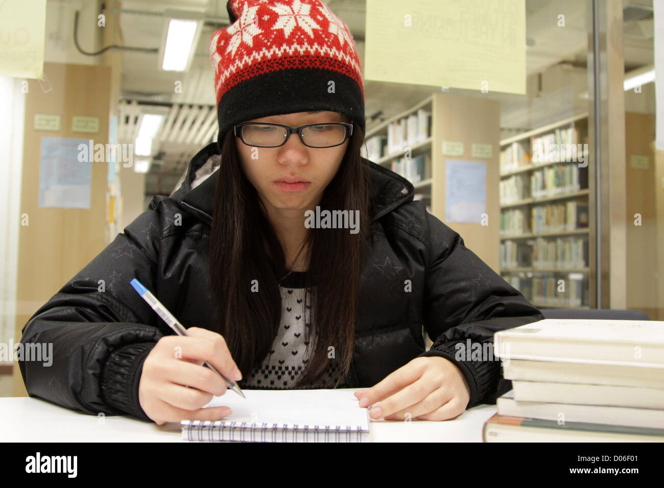 Asian woman studying in library Stock Photo - Alamy