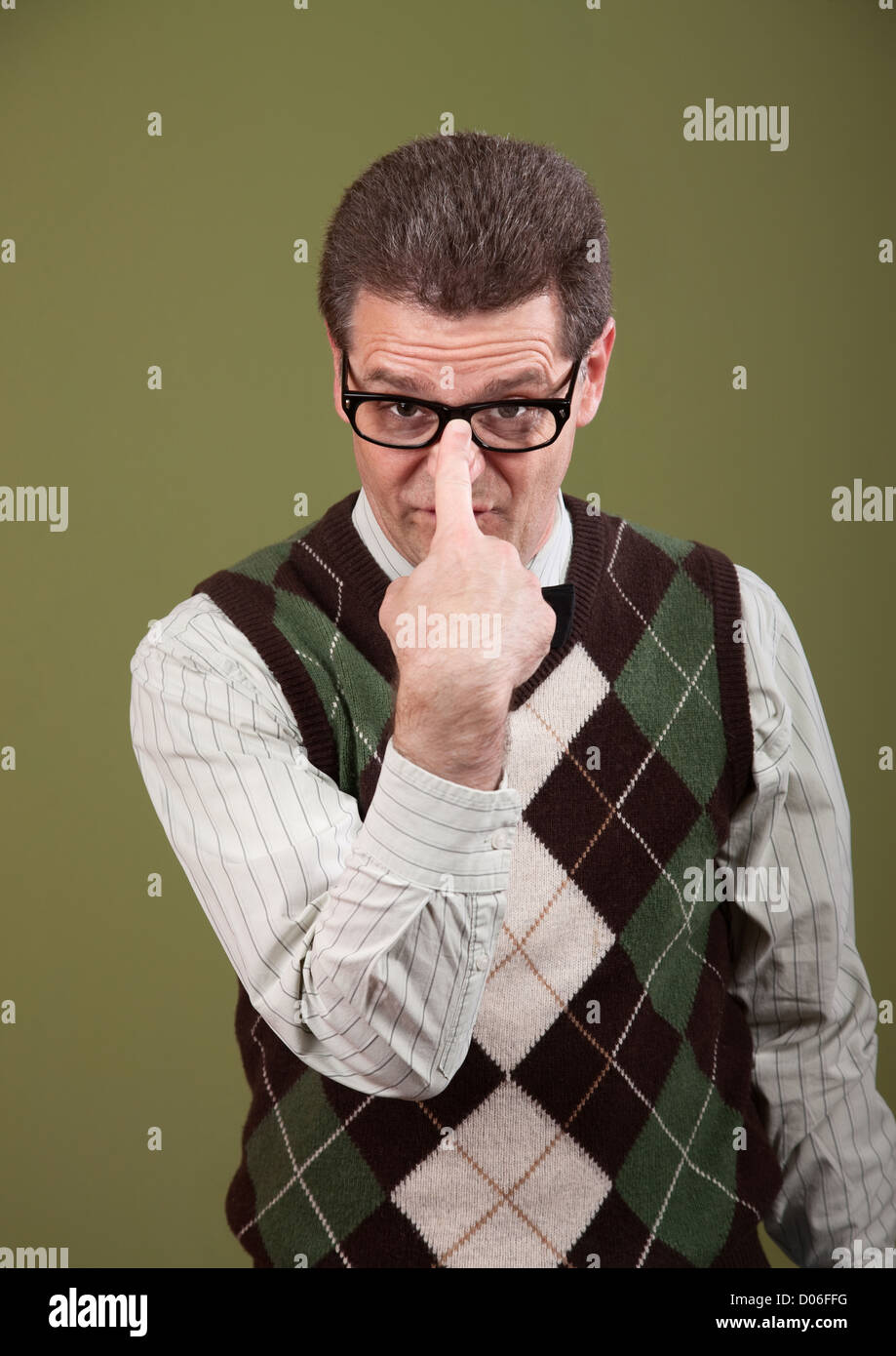 Nerd over a green background adjusts his eyeglasses Stock Photo - Alamy