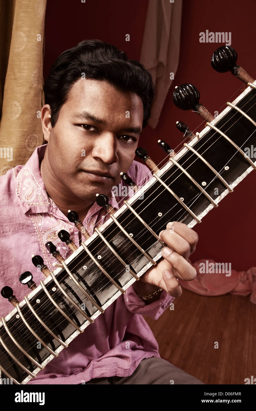 Handsome Indian man in traditional attire plays a Sitar Stock Photo - Alamy