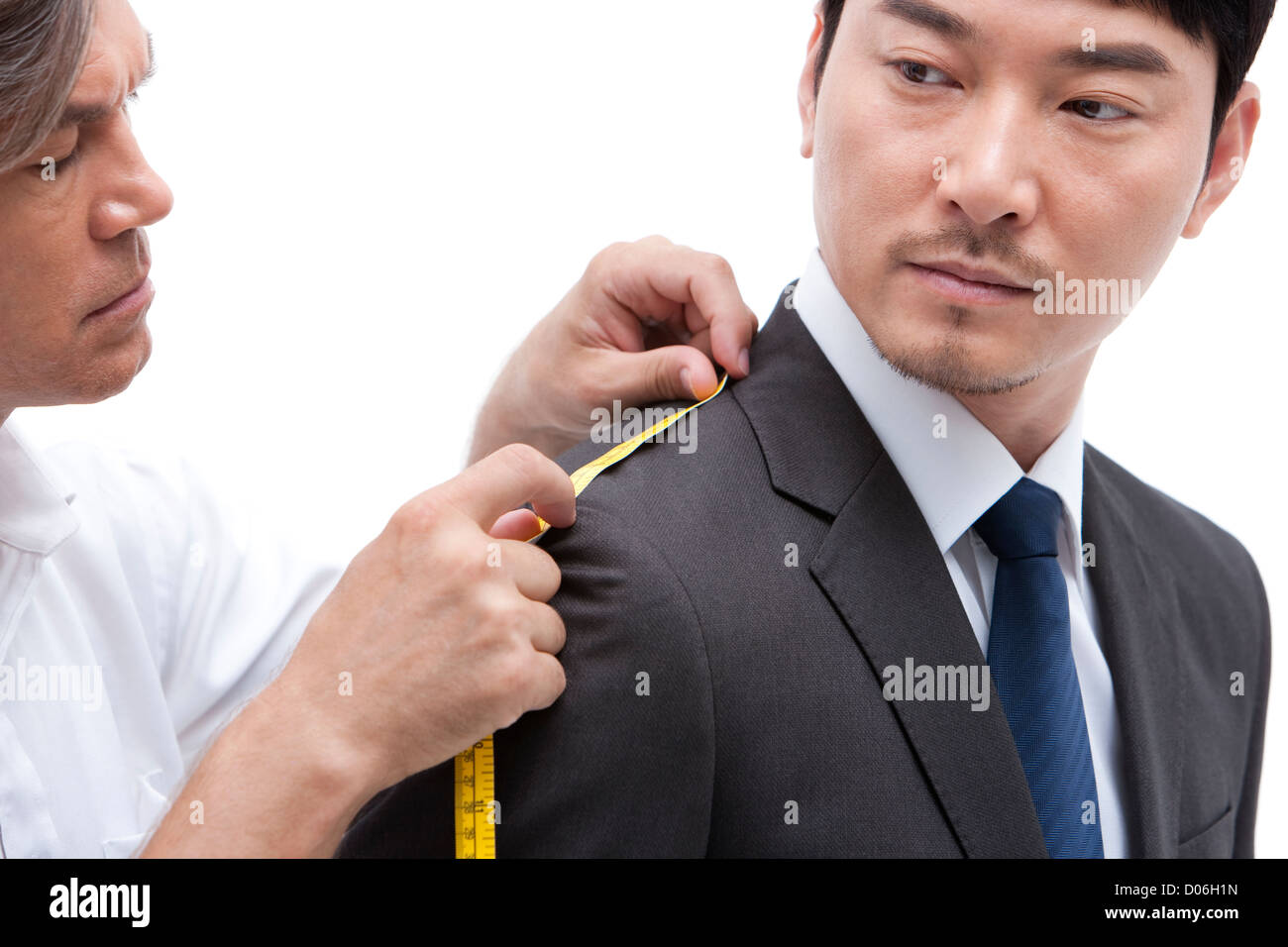 Fashion designer taking a measurement of businessman Stock Photo - Alamy
