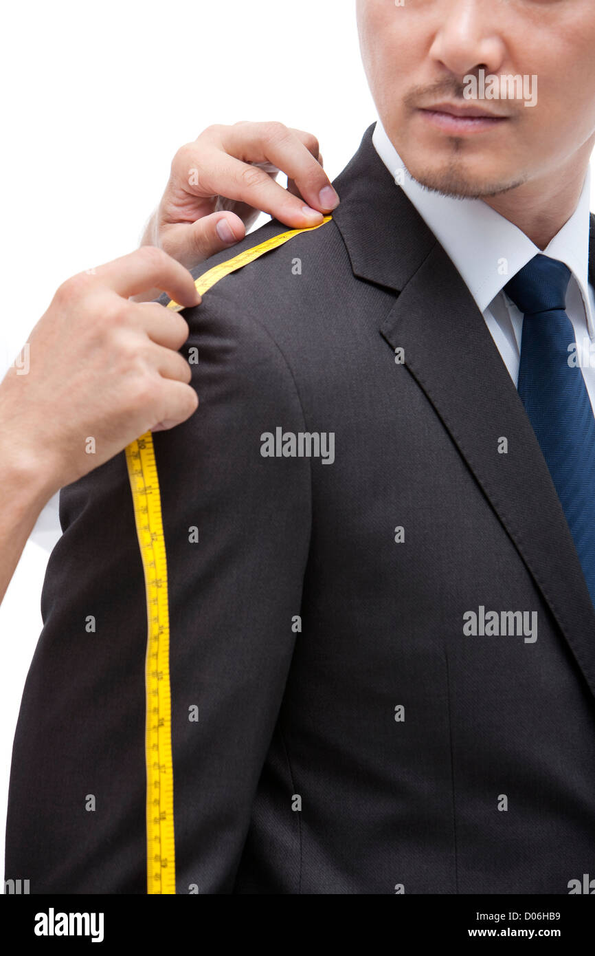 Fashion designer taking a measurement of businessman Stock Photo - Alamy