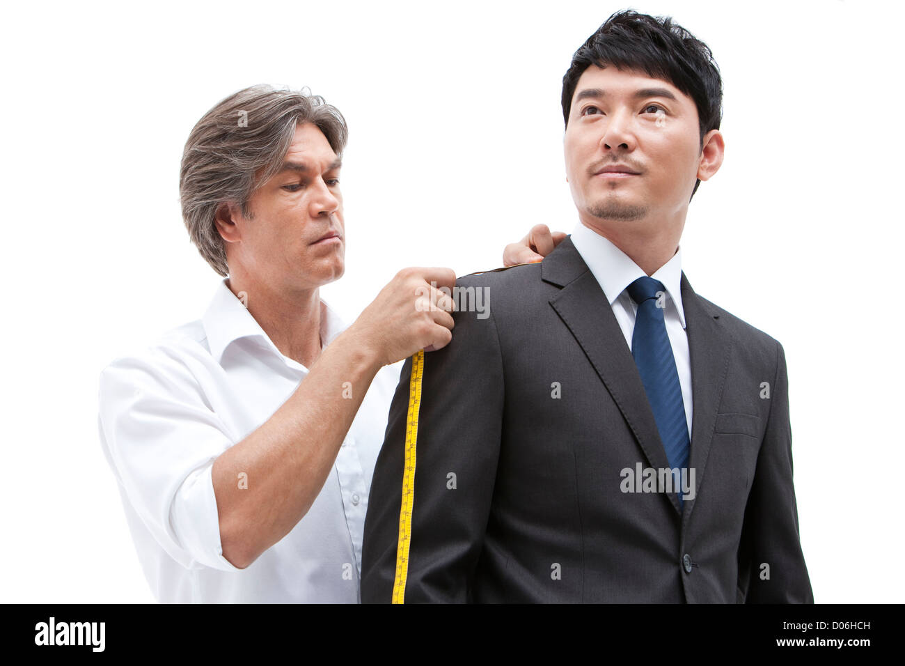 Fashion designer taking a measurement of businessman Stock Photo - Alamy