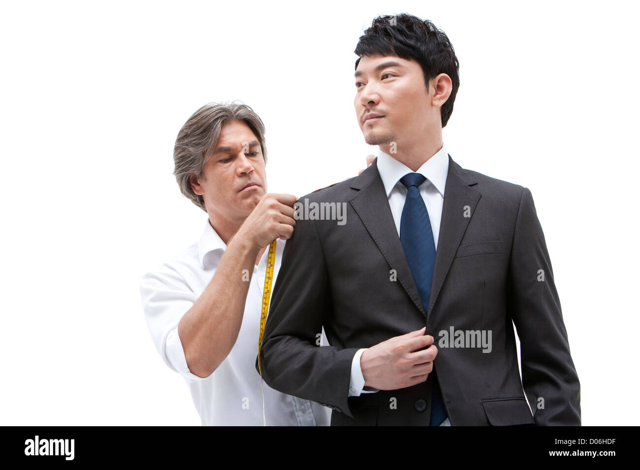 Fashion designer taking a measurement of businessman Stock Photo - Alamy
