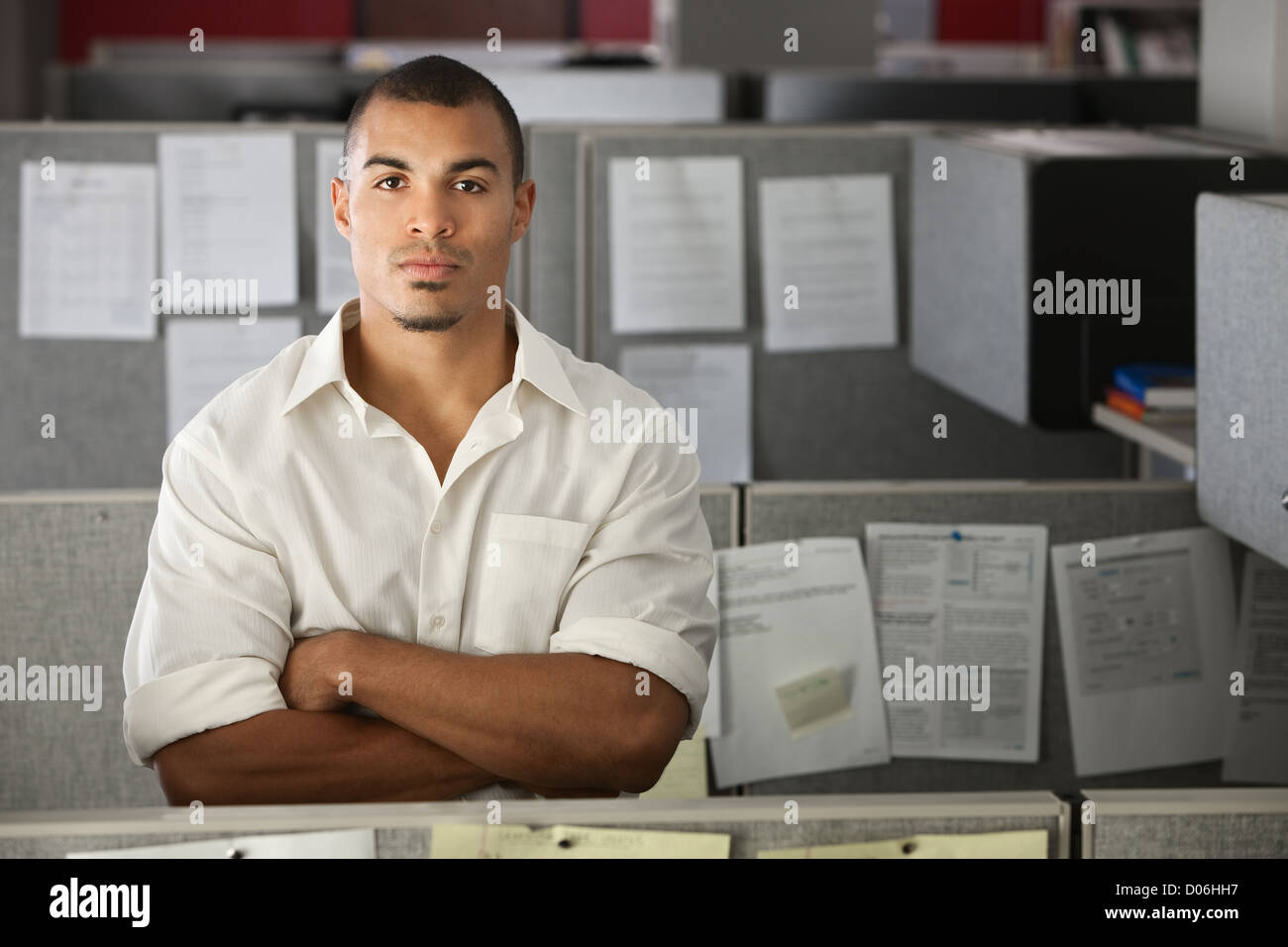 Confident office worker with hands folded standing in his cubicle Stock ...