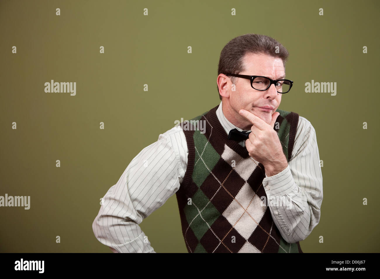 Nerd expressing doubt over green background Stock Photo - Alamy