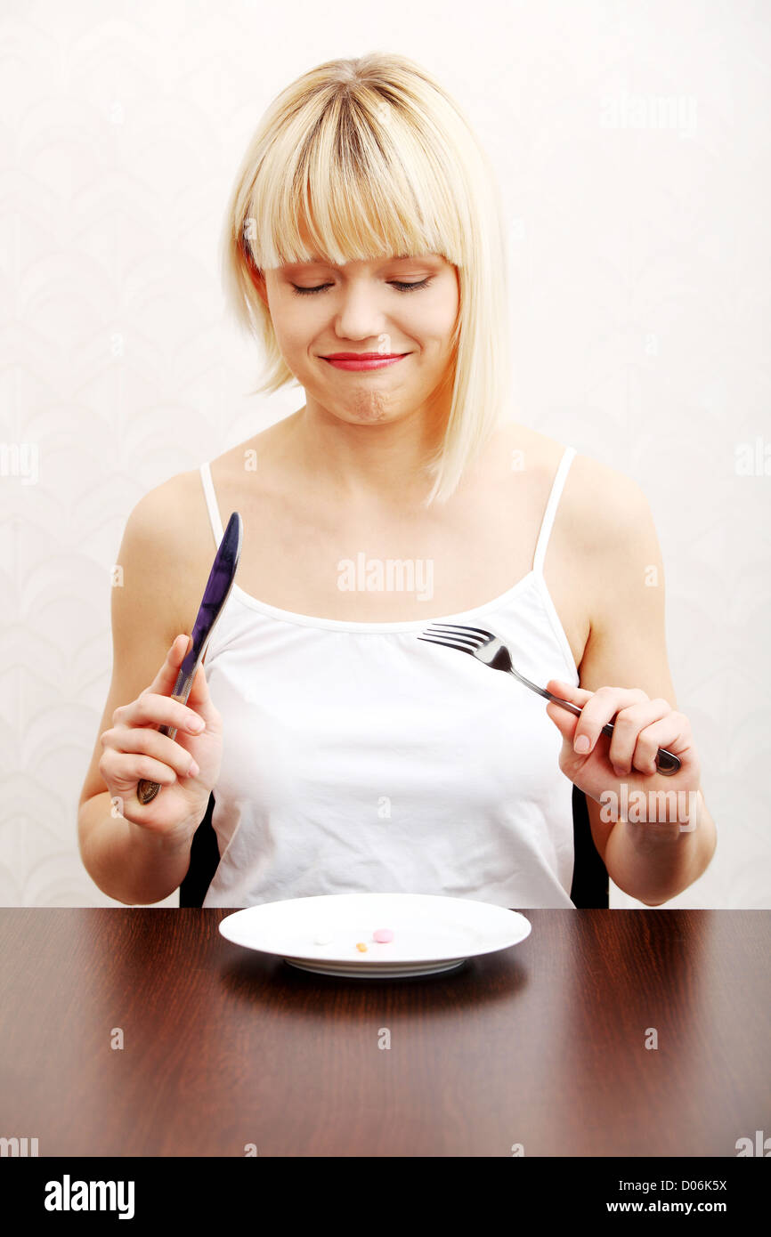 Woman eating nutritional supplement - pills on plate Stock Photo - Alamy