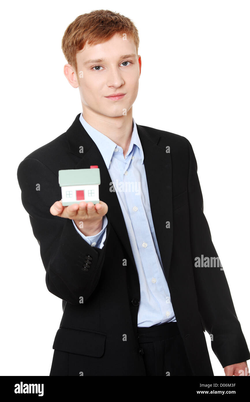 Young business man holding house model - real estate concept. Isolated ...