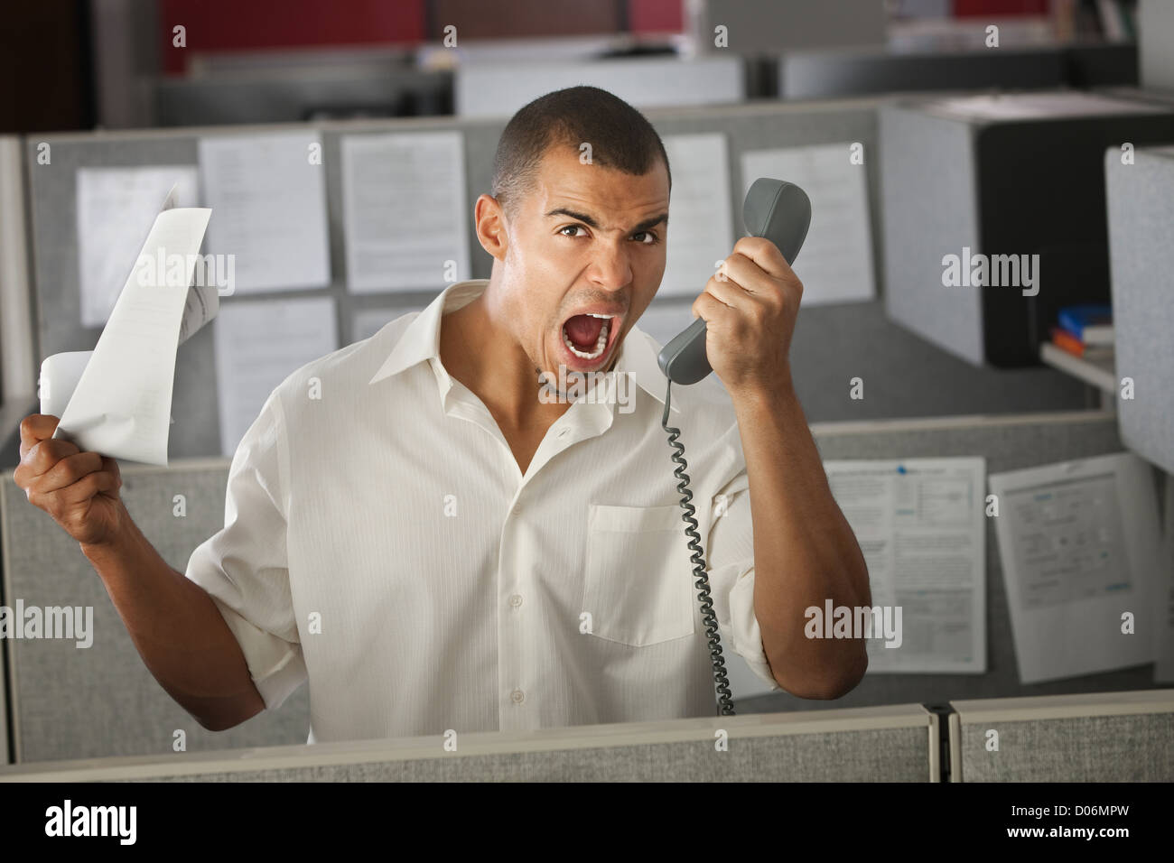 Frustrated office worker yelling on phone in his cubicle Stock Photo ...