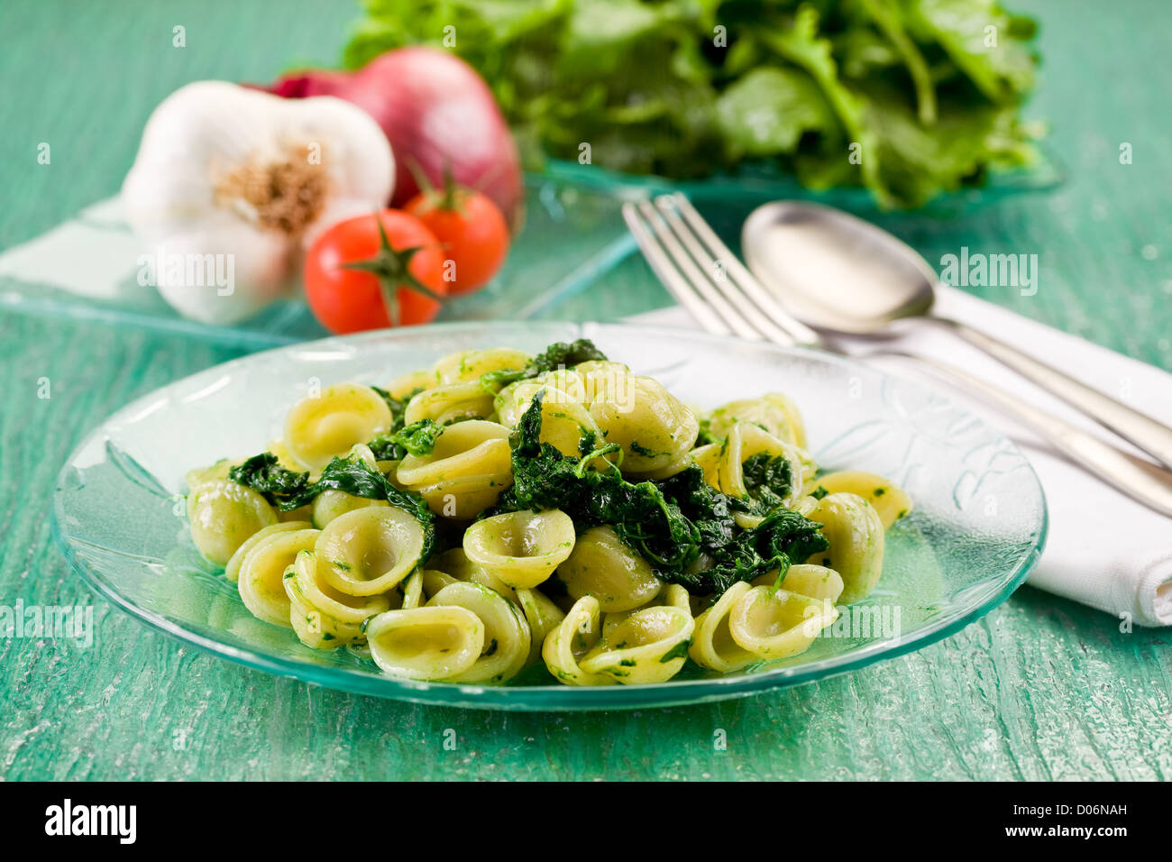 Italian Regional dish with pasta and turnip tops on green glass table ...