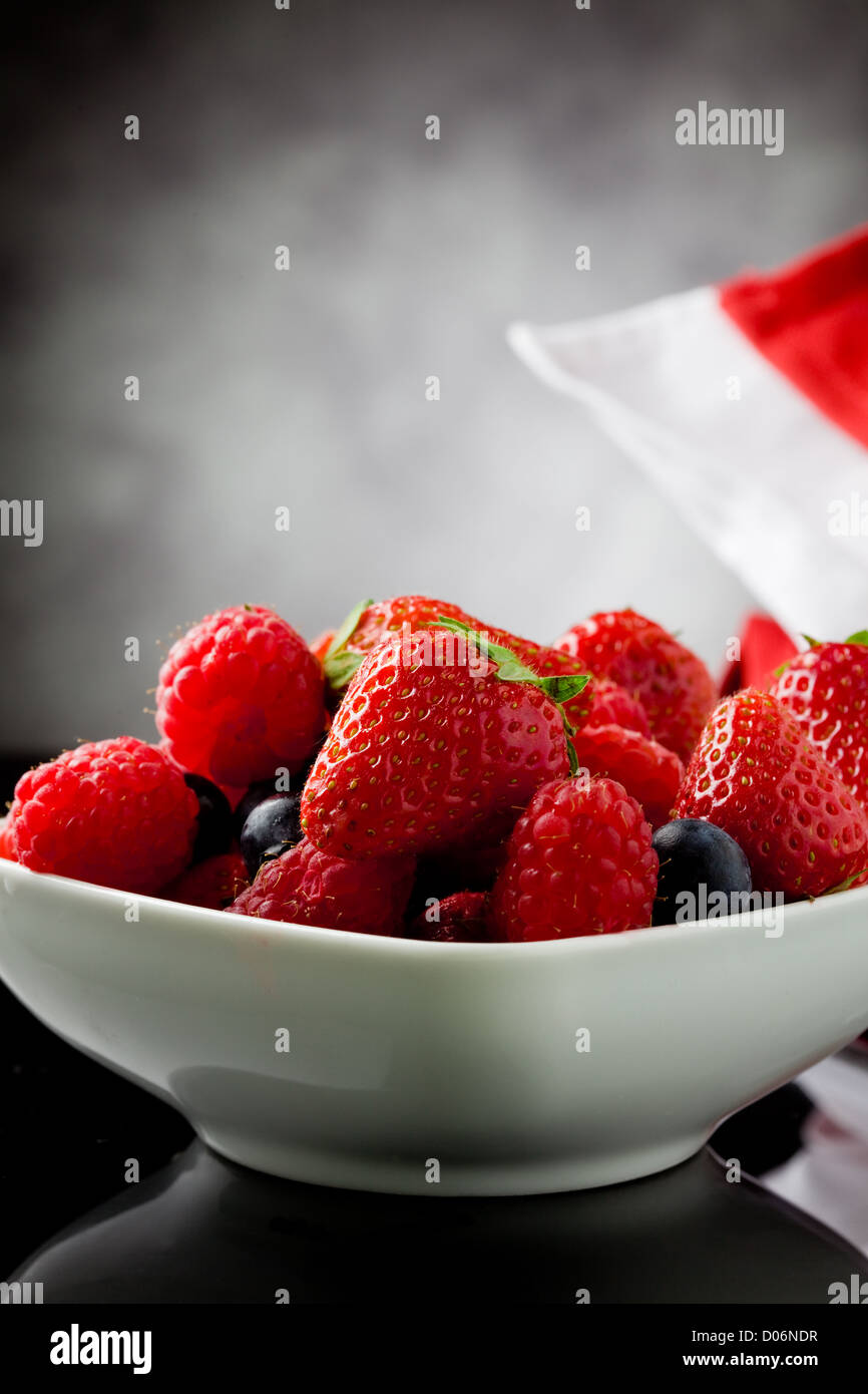 photo of mixed fresh berries on grey lighted background Stock Photo - Alamy
