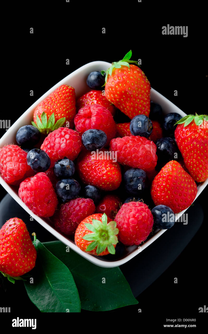 photo of mixed fresh berries on red lighted background Stock Photo - Alamy