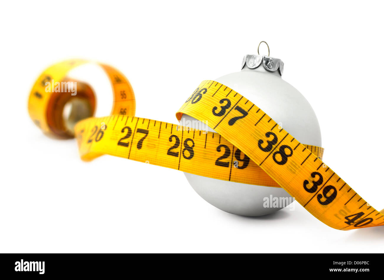 Tape measure around a bauble concept symbolizing Christmas weight gain ...