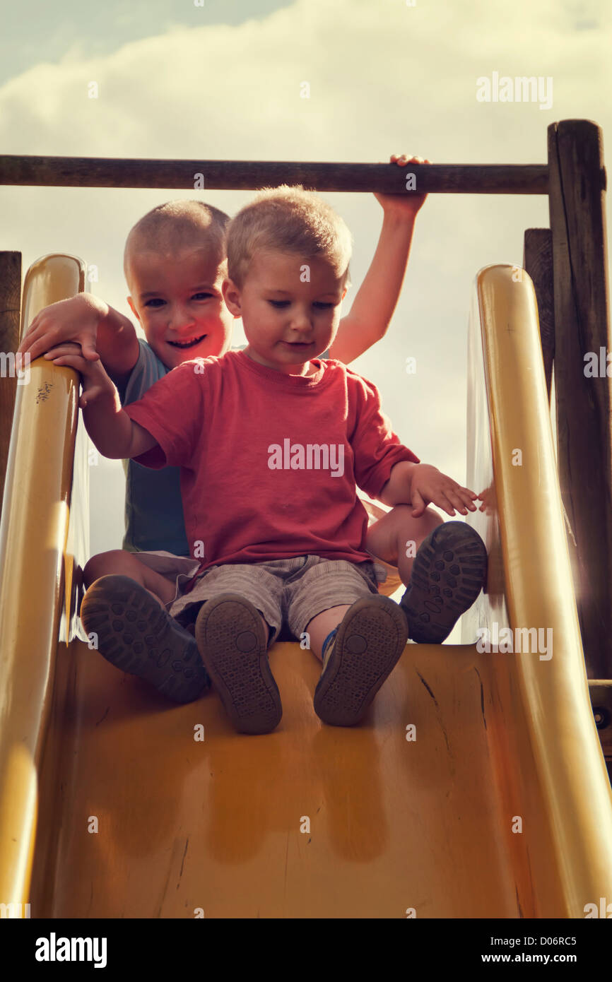 Two kids slide on playground hi-res stock photography and images - Alamy