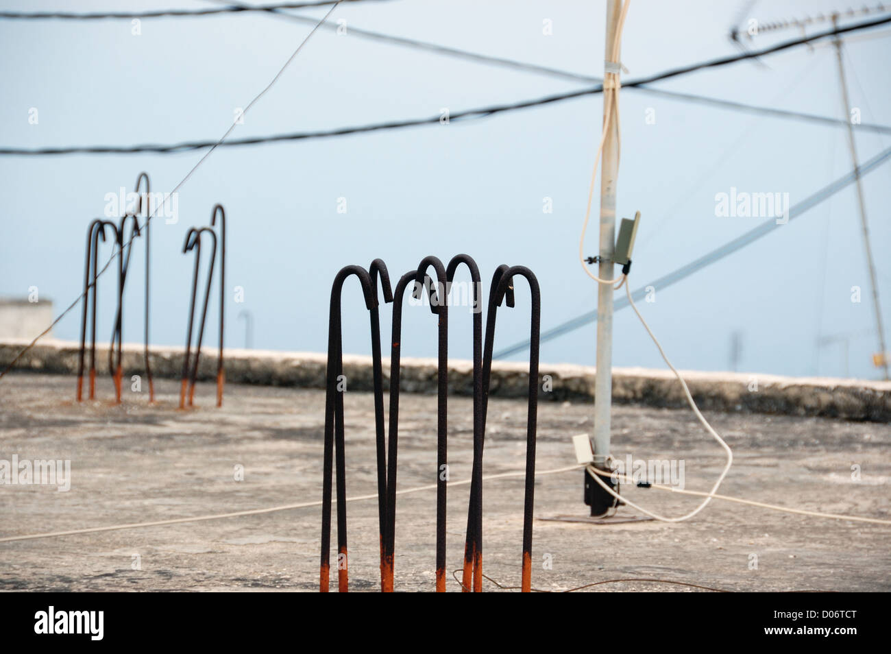 Concrete rooftop, construction bars, antenna and wires Stock Photo - Alamy