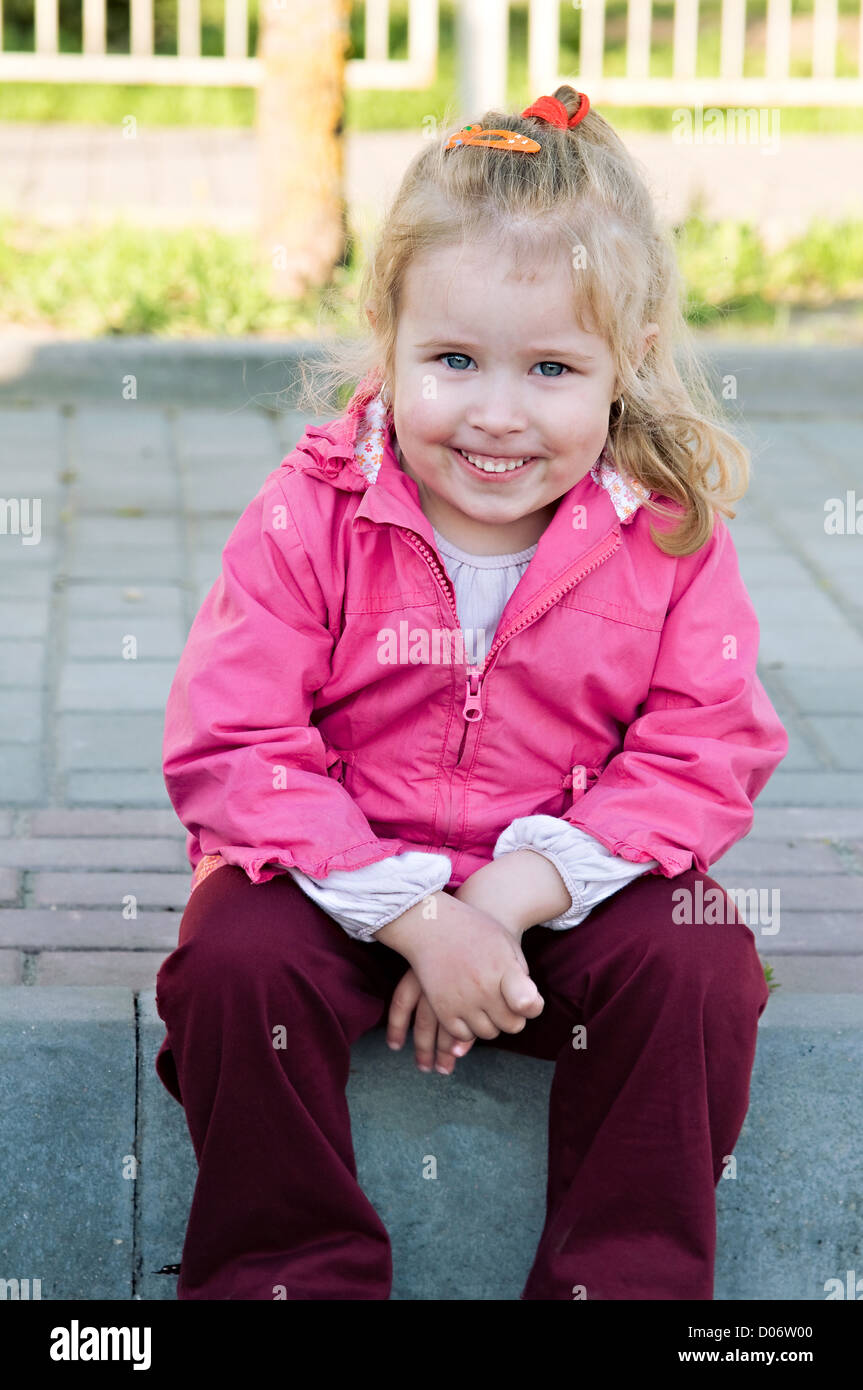 girl in a pink jacket, sitting and smiling Stock Photo - Alamy