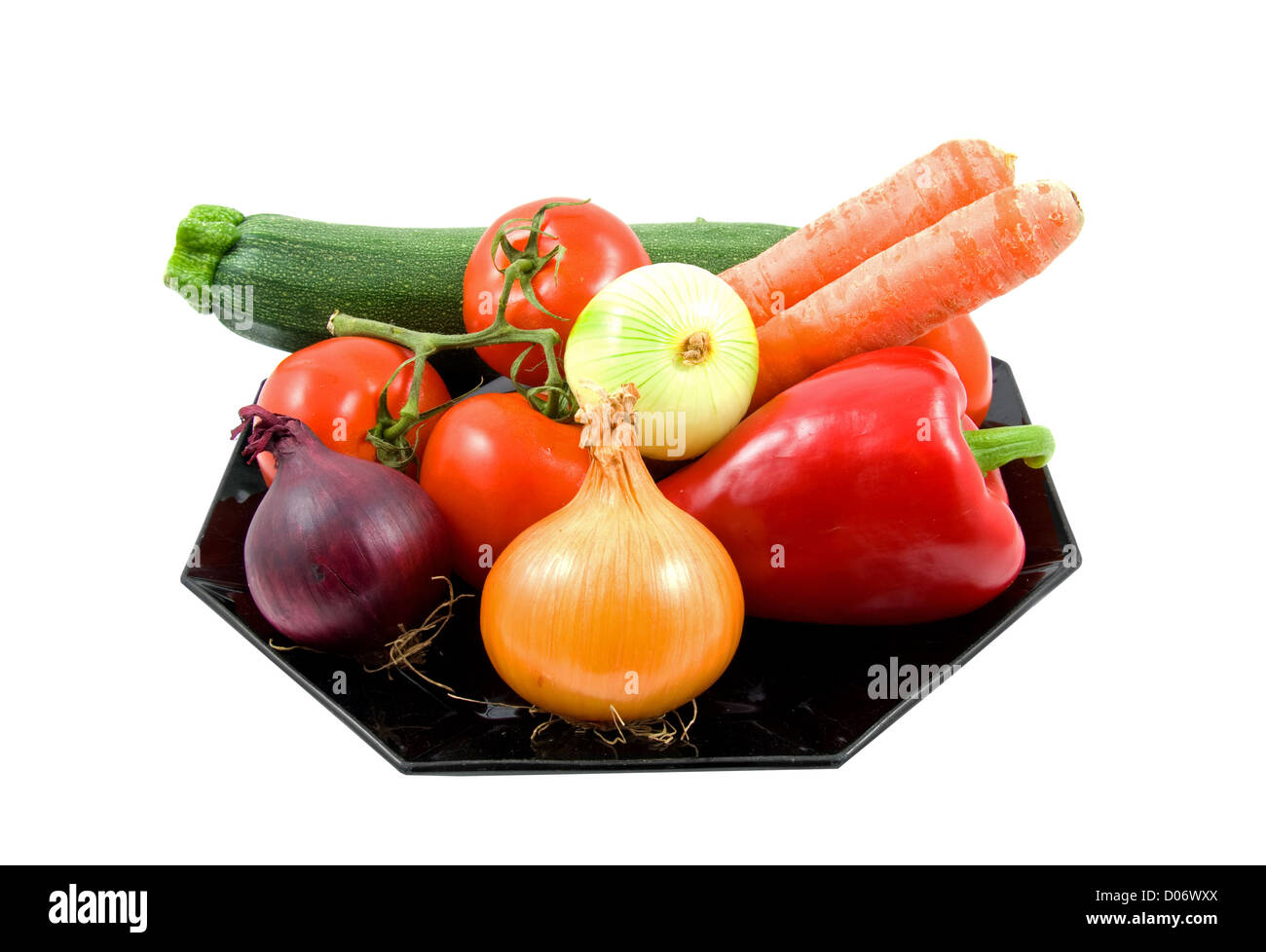 Black plate filled with fresh vegetables isolated on white background ...