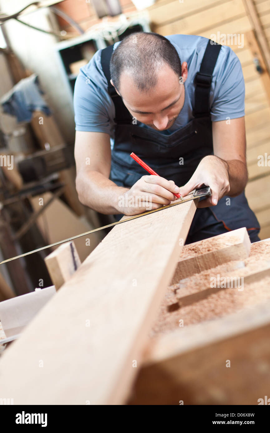 Worker measuring a beech wood plank Stock Photo - Alamy