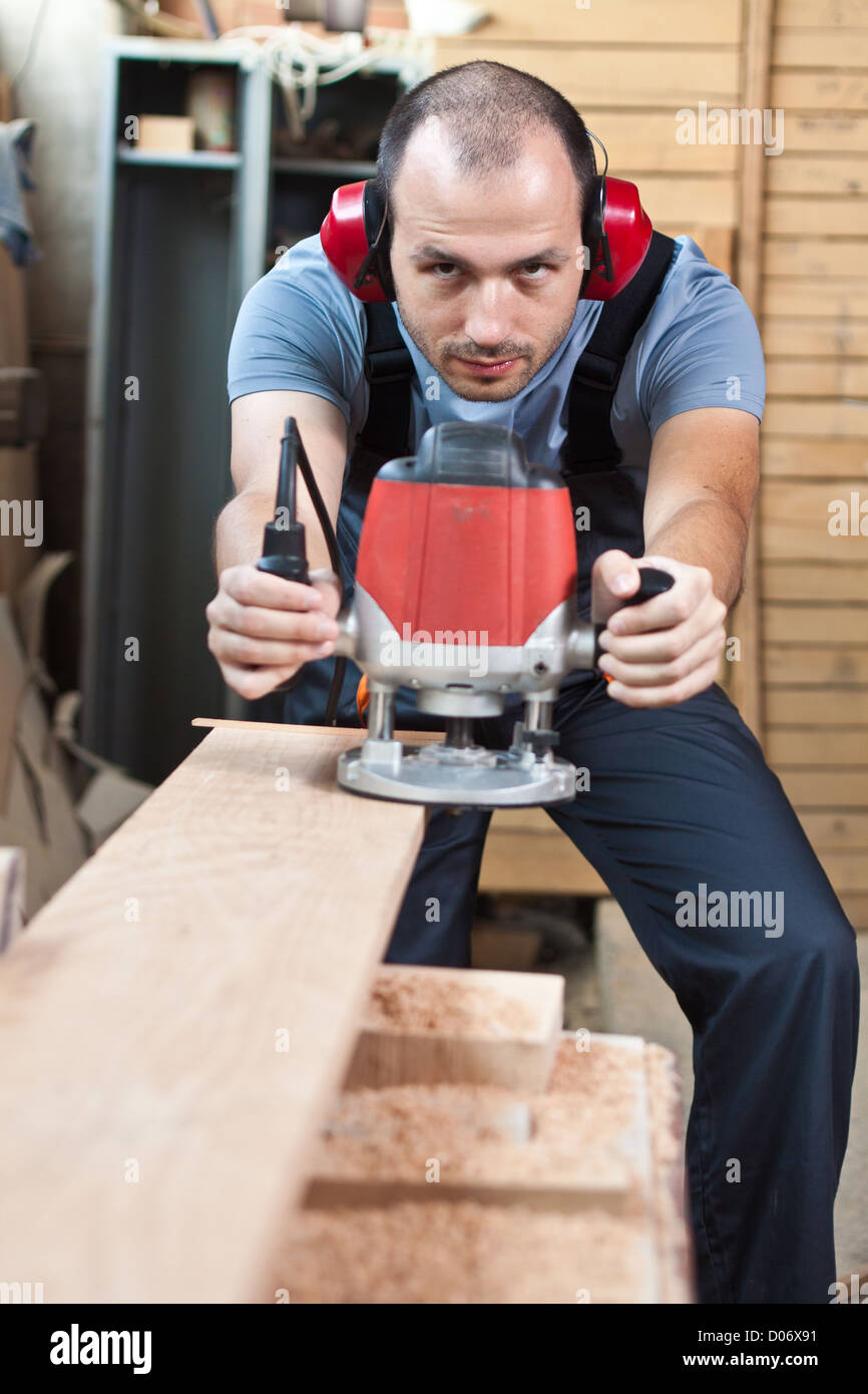 Man working with a router, vertical shot with copy space Stock Photo ...