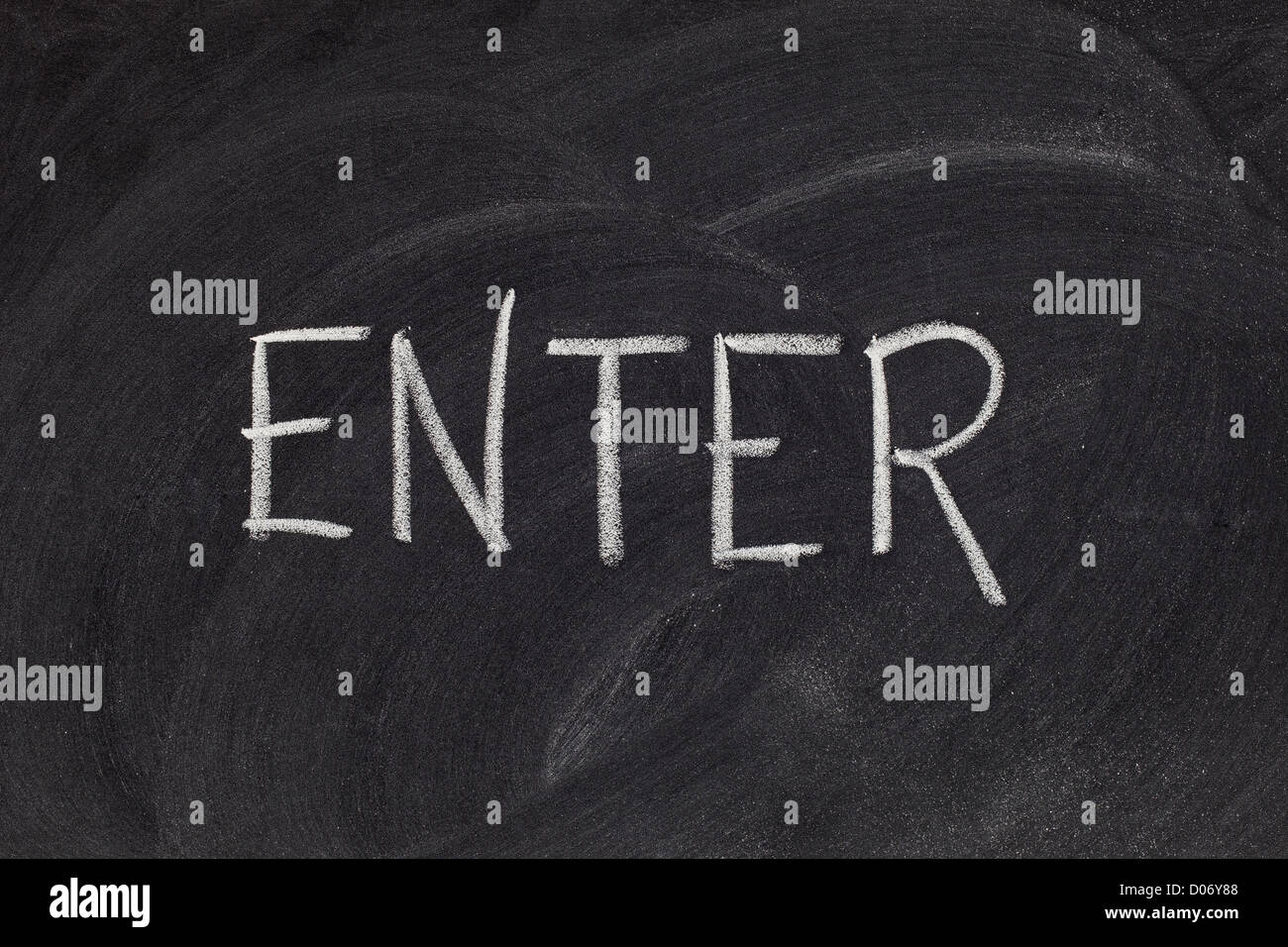 enter - white chalk handwriting on blackboard with eraser patterns ...