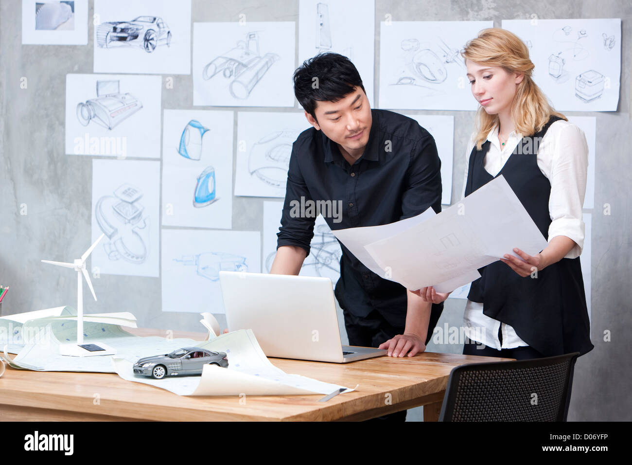 Designers studying blueprint in studio Stock Photo - Alamy