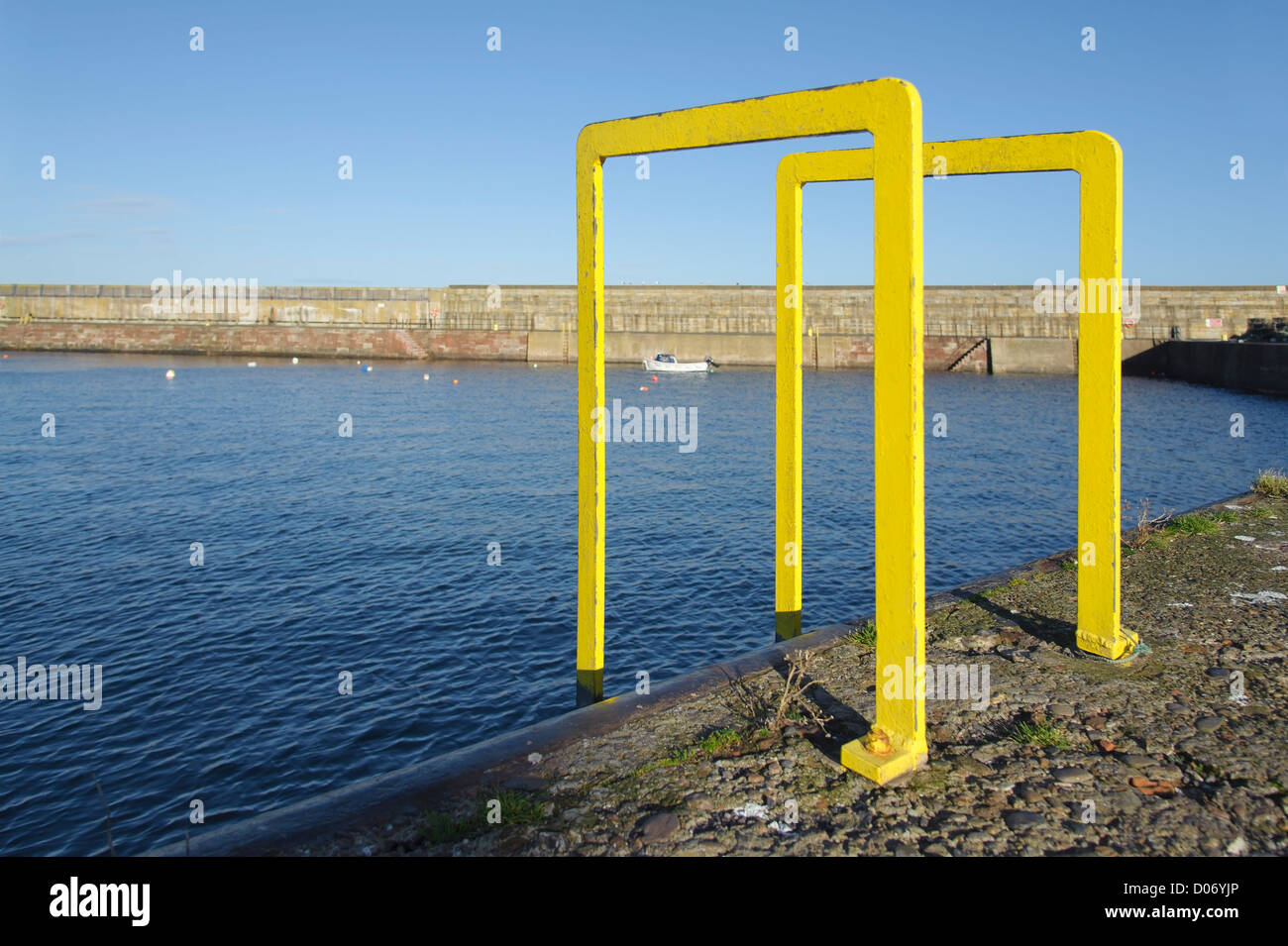 A yellow painted ladder at the harbour in the traditional fishing ...