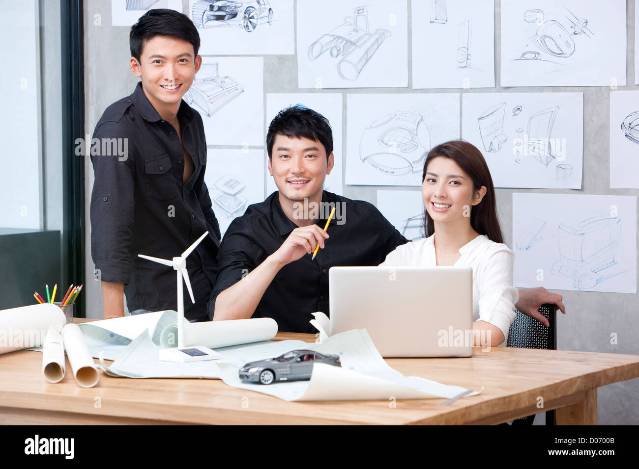 Designer team working before laptop in studio Stock Photo - Alamy
