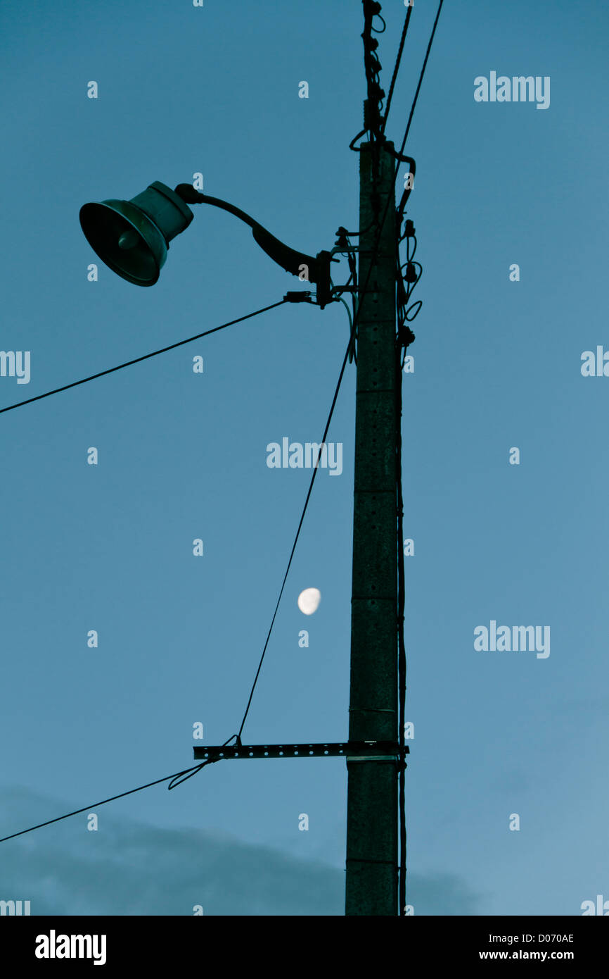 Telegraph pole at dusk with moon in sky Stock Photo - Alamy