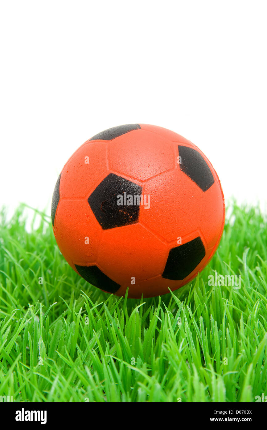 Orange soccer ball on grass over white background Stock Photo - Alamy