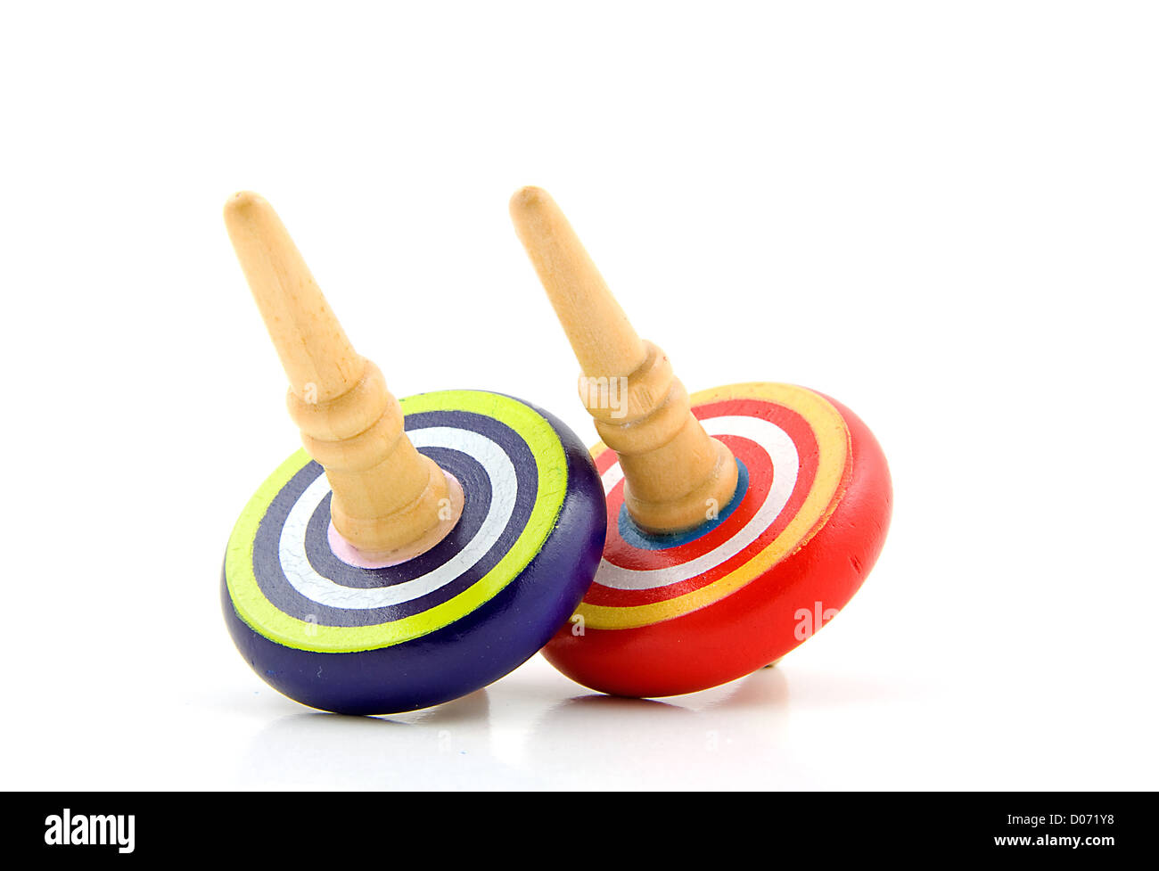 Two spinning tops isolated on white background Stock Photo - Alamy