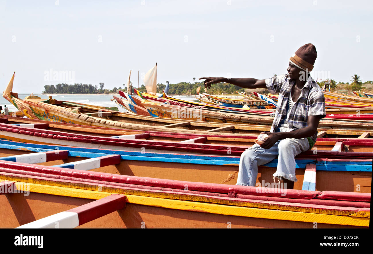 Gambian fisherman with boats on river bank Stock Photo - Alamy