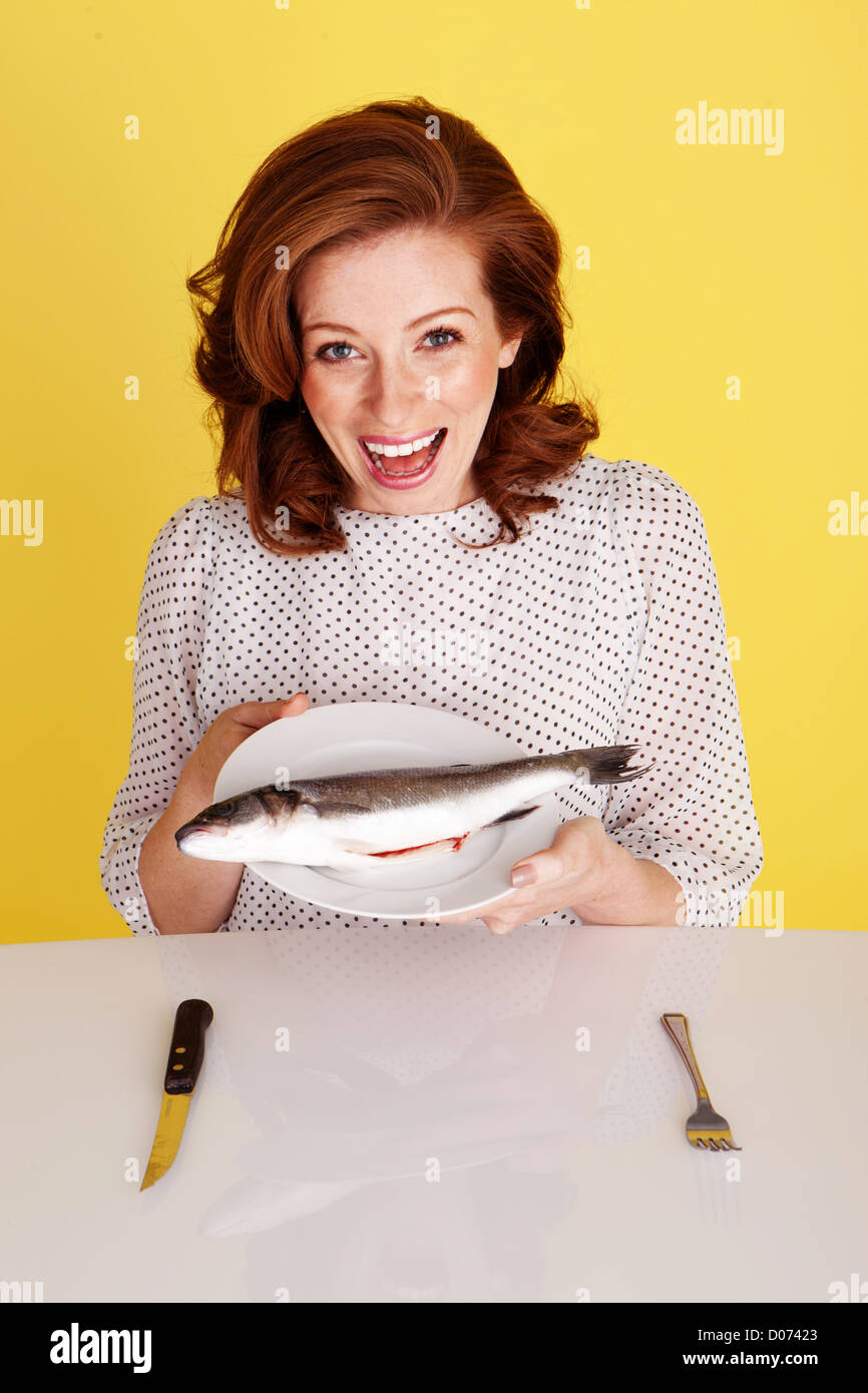 pretty woman with a fish on the plate Stock Photo - Alamy